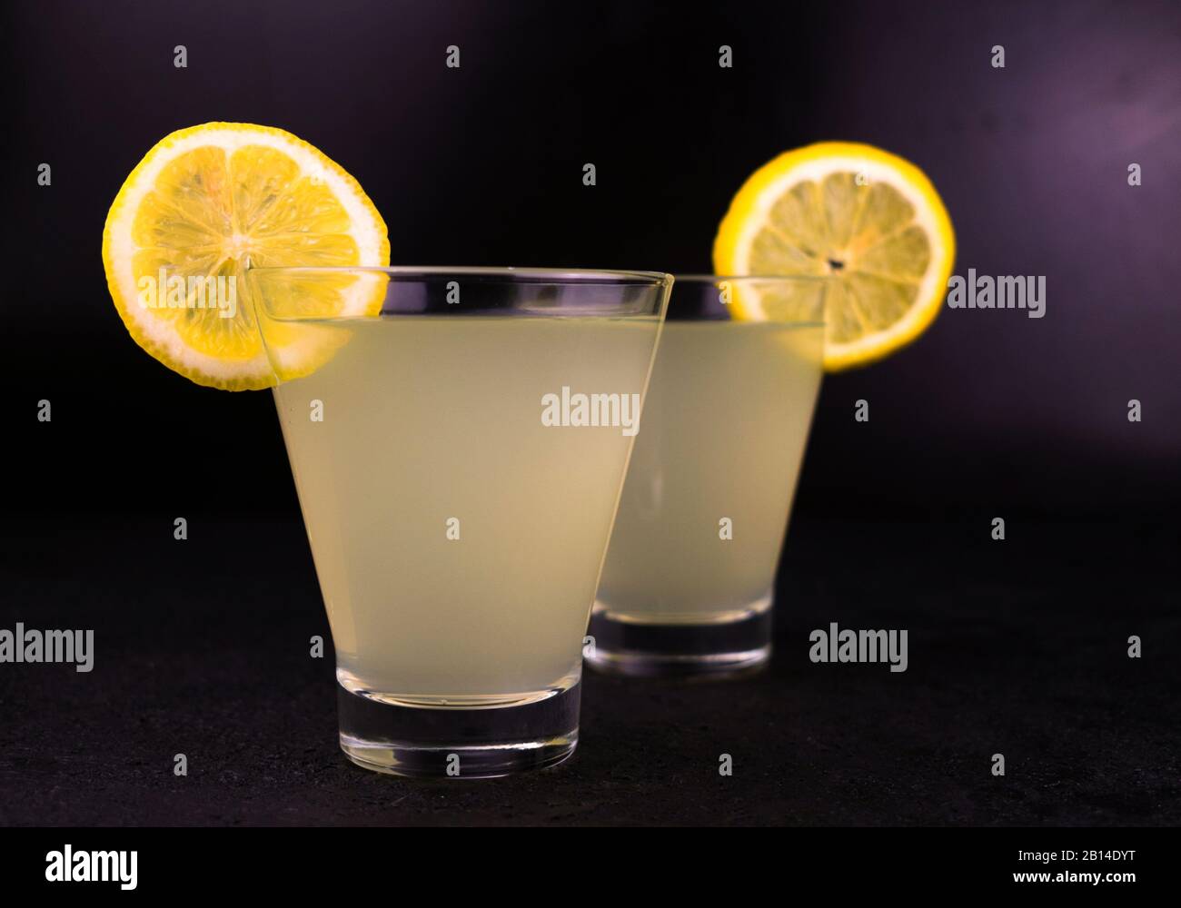 Two glasses with lemon juice on a black background Stock Photo - Alamy