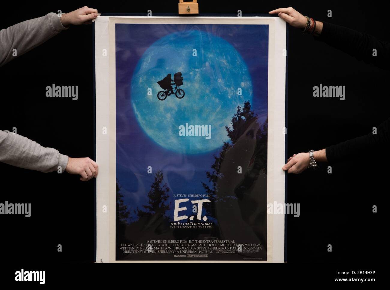 Prop Store employees hold a US One-Sheet Poster for the 1982 film 'E.T ...