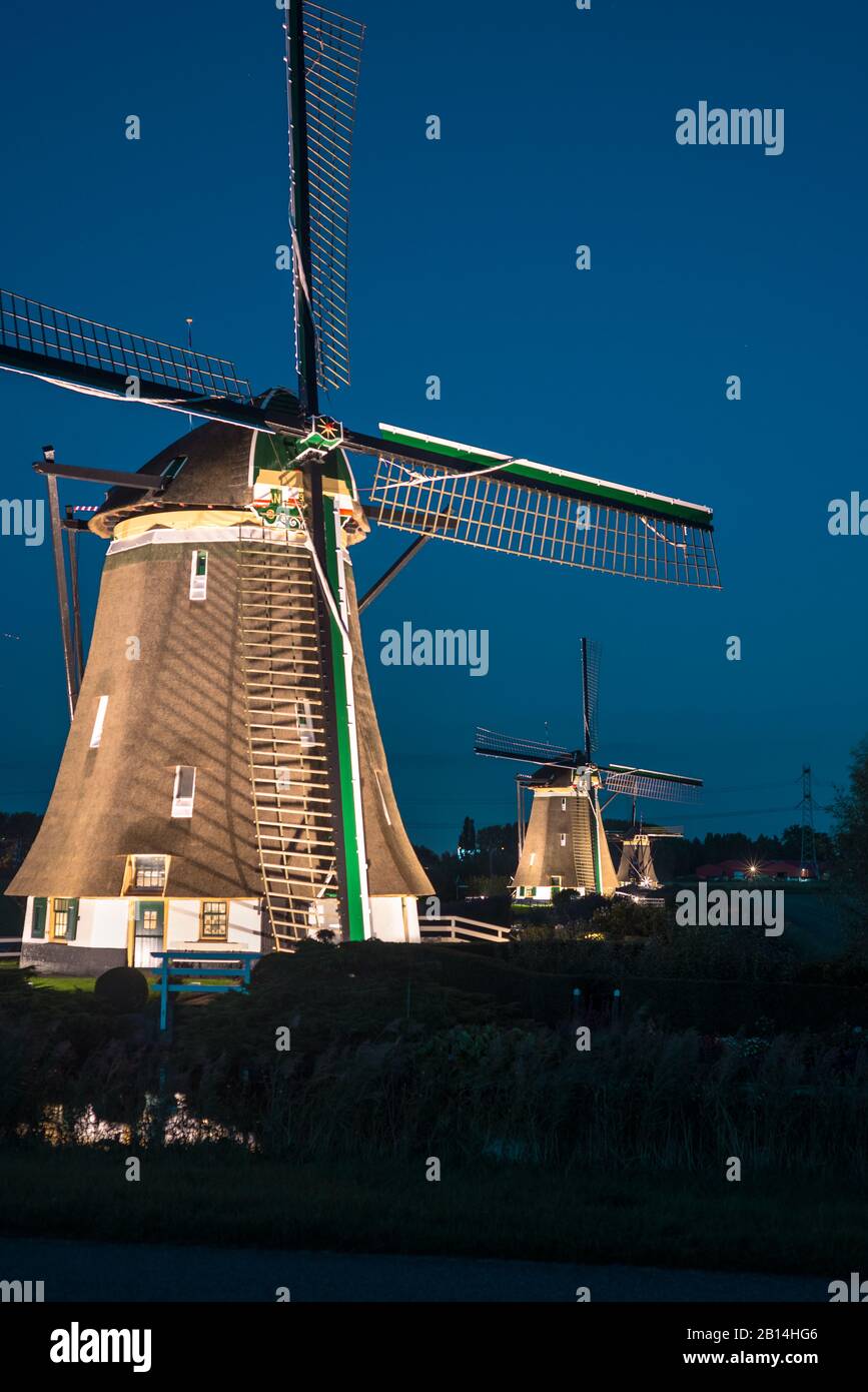 Beautiful landscape image of dutch windmills that are illuminated by ...