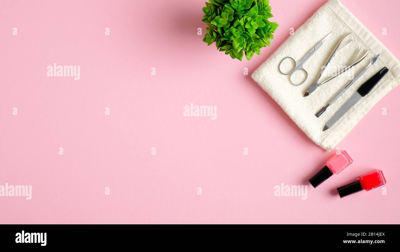 Nail salon table with manicure tools and nail polish bottles on pink ...