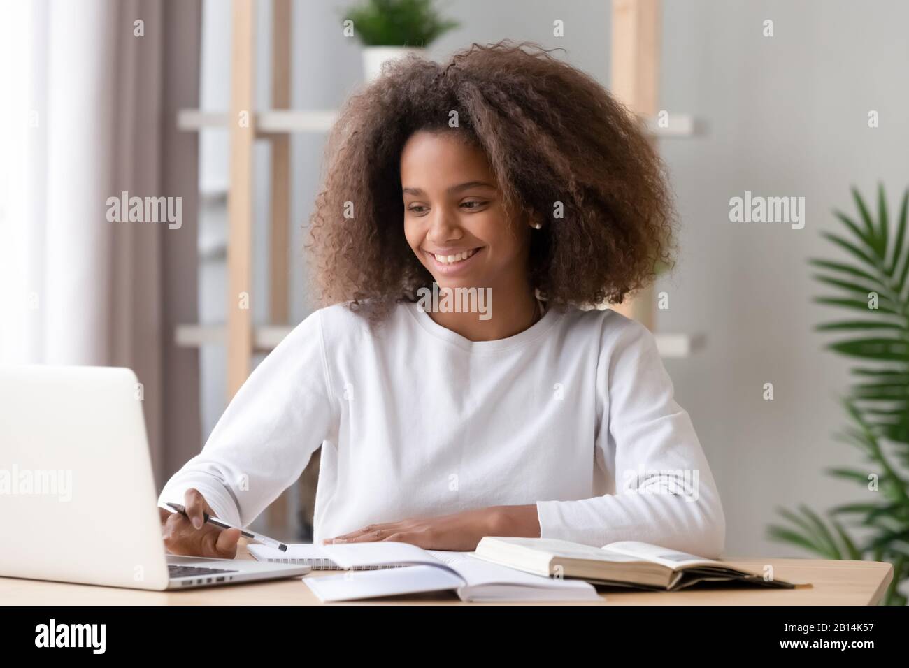 Happy african american teen high school student studying with laptop ...