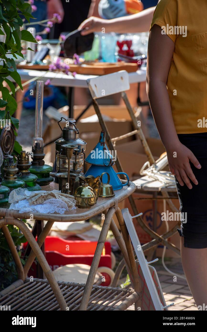 Flea market on a long crowded street, a lot of people selling their ...
