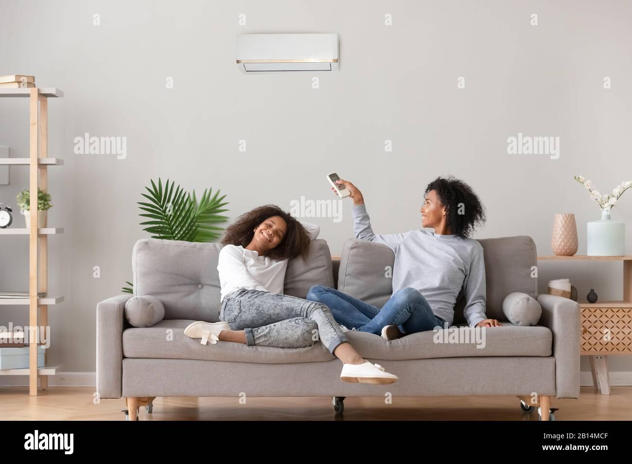 Happy african american family relaxing on sofa under air conditioner Stock Photo - Alamy