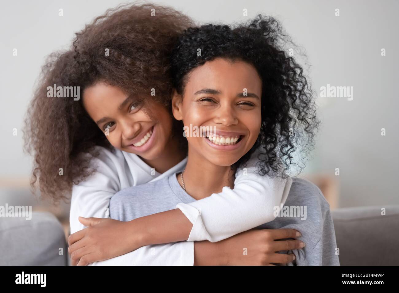 Happy african family mother and teen girl embracing mom, portrait Stock Photo - Alamy