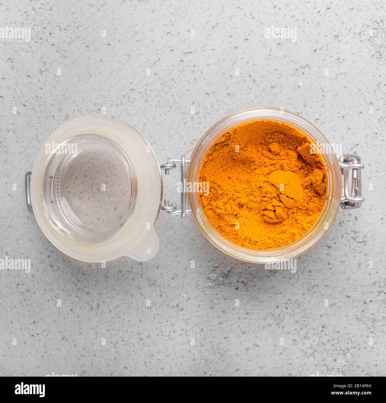 Organic turmeric curcuma powder in glass jar on concrete Stock Photo ...