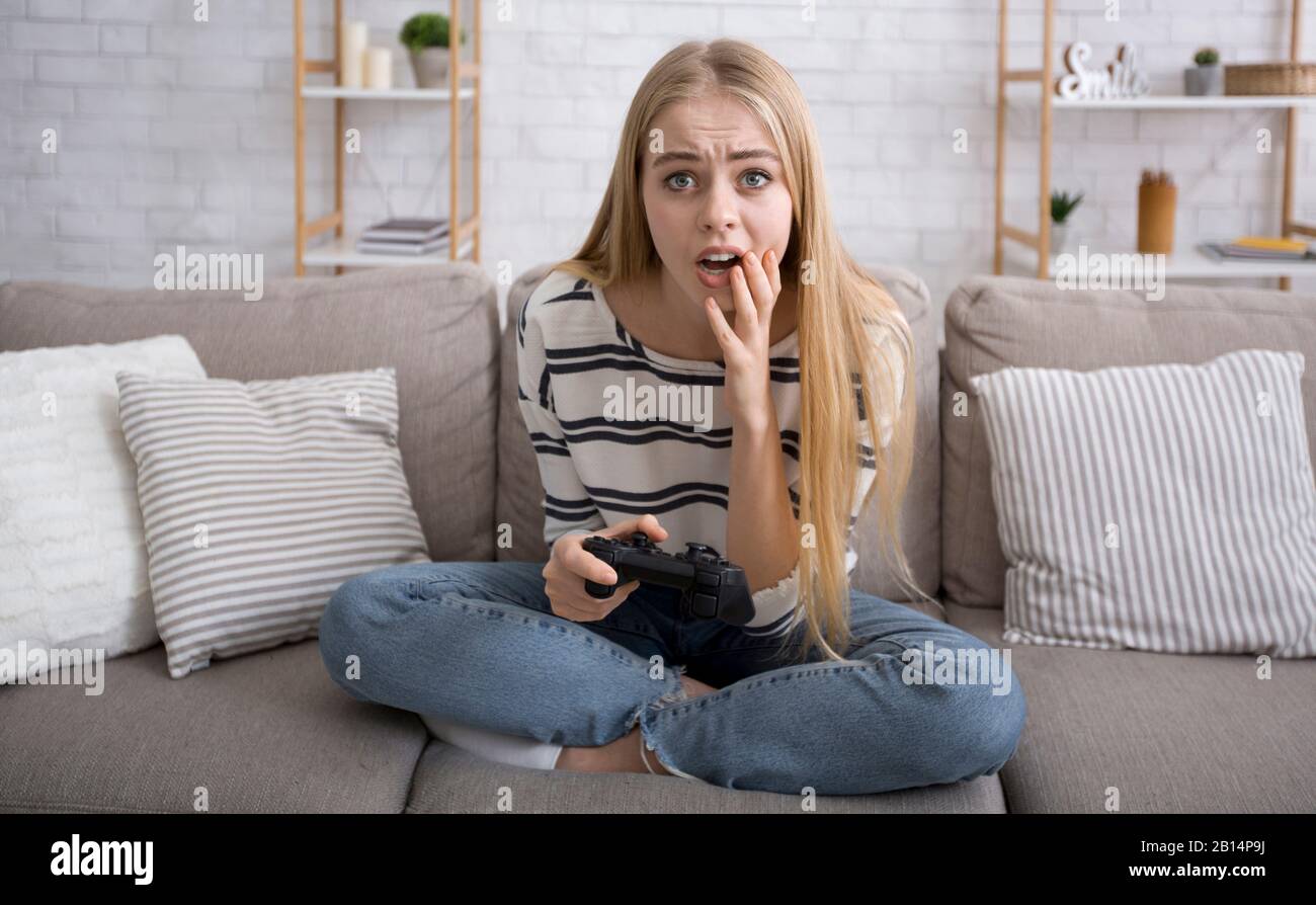 Shocked girl with joystick got stuck during video game Stock Photo - Alamy