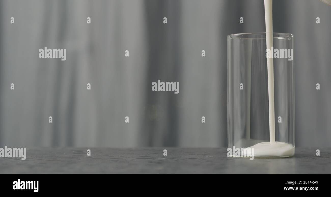 pour white yogurt into glass on concrete countertop, wide photo Stock ...