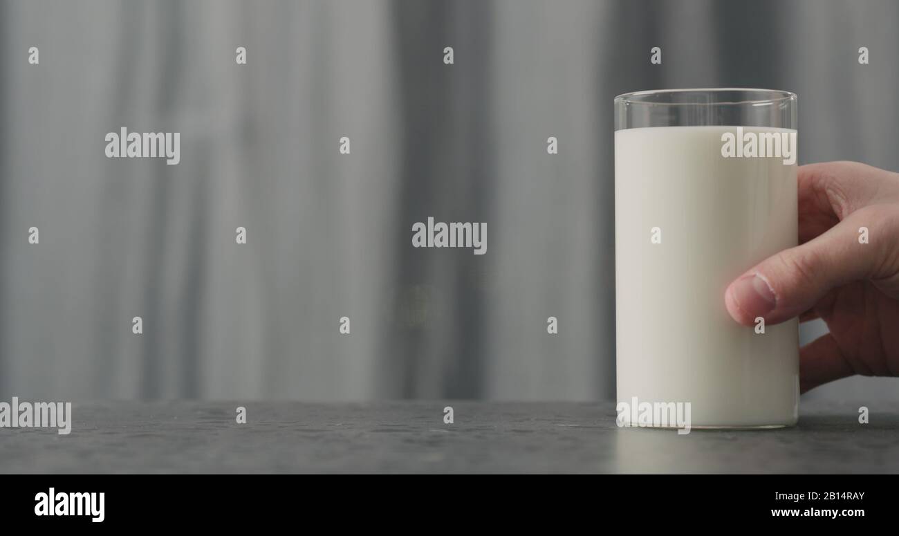 man hand take glass with white yogurt on concrete countertop, wide ...