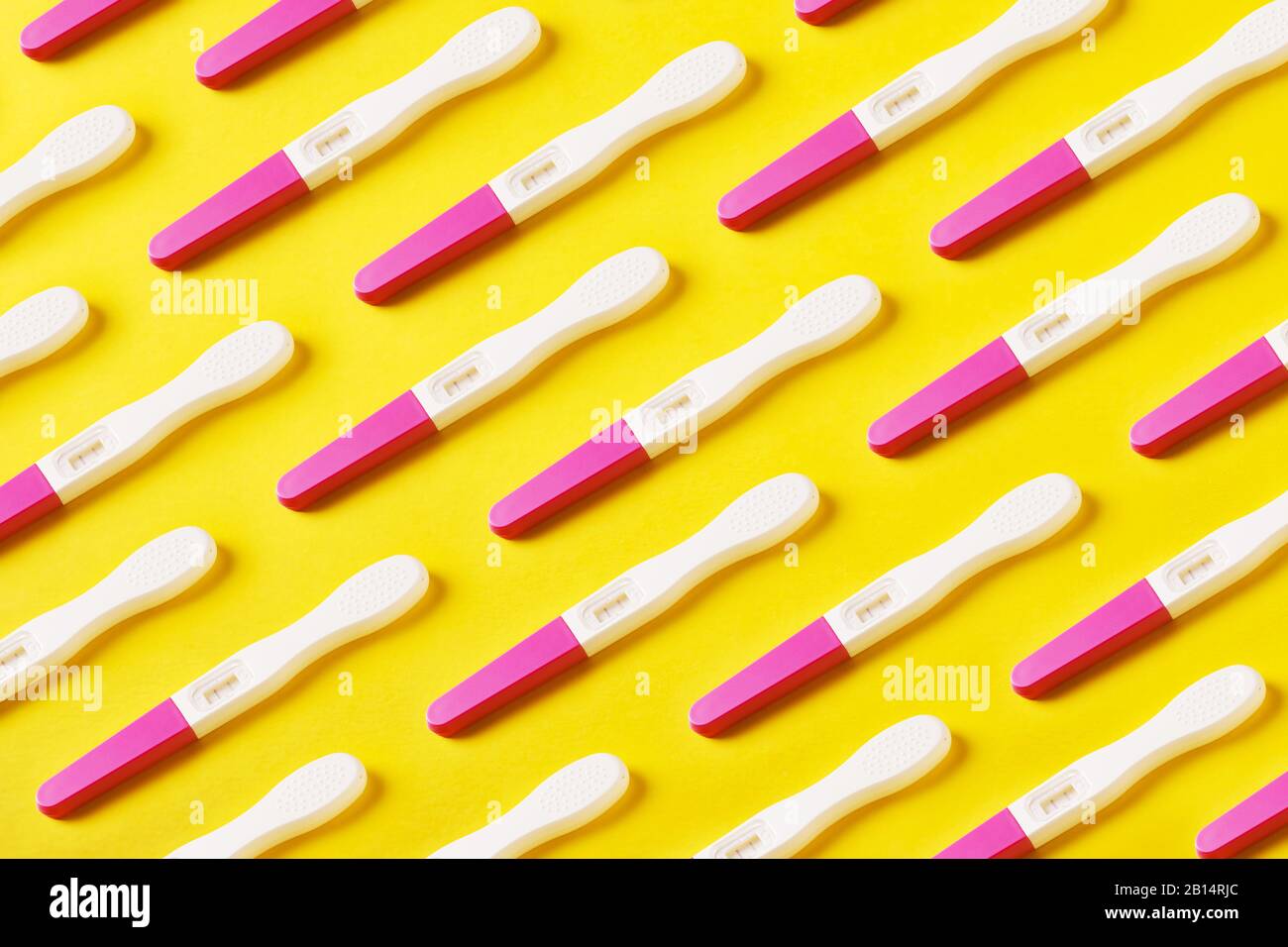 positive pregnancy tests pattern over yellow background, awaiting the ...