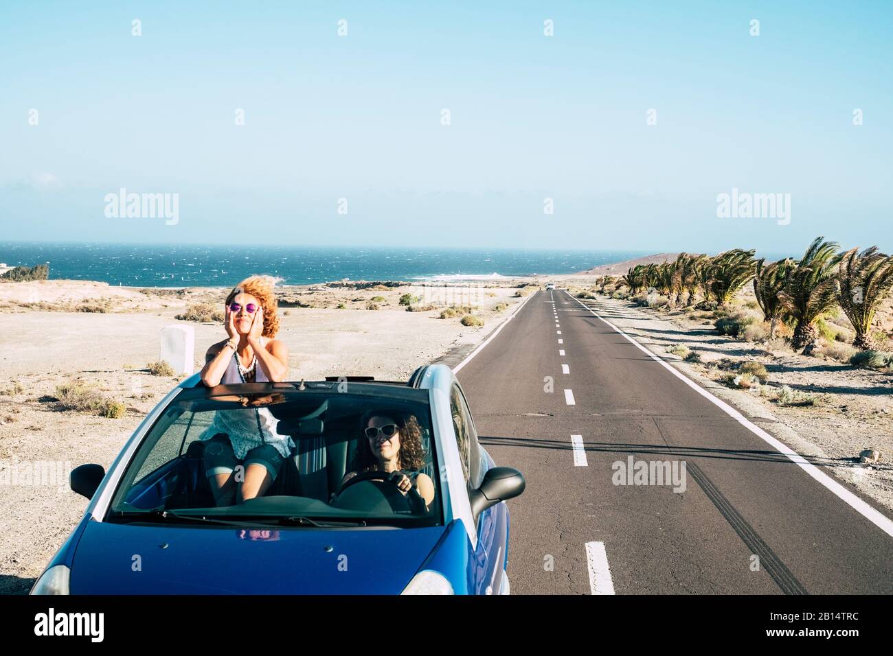 Travel friends and transport with blue convertible car and couple of ...