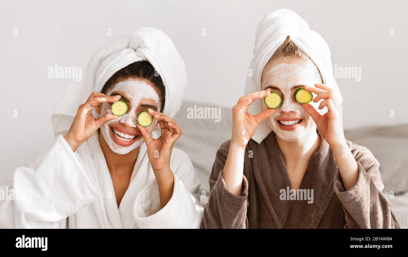 Ladies in bathrobes and face masks covering eyes with avocado Stock ...