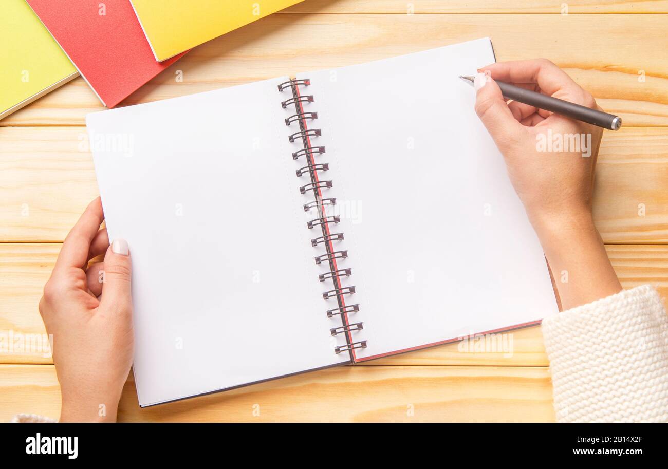 Female hands drawing in a spiral notebook at the wooden desk Stock ...