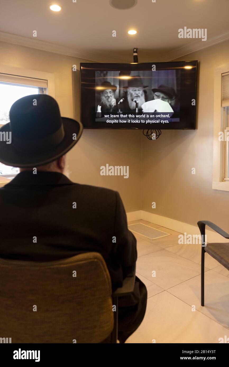 A rabbi watches a 1970's video of the Lubavitcher Rebbe at the Rebbe's ...