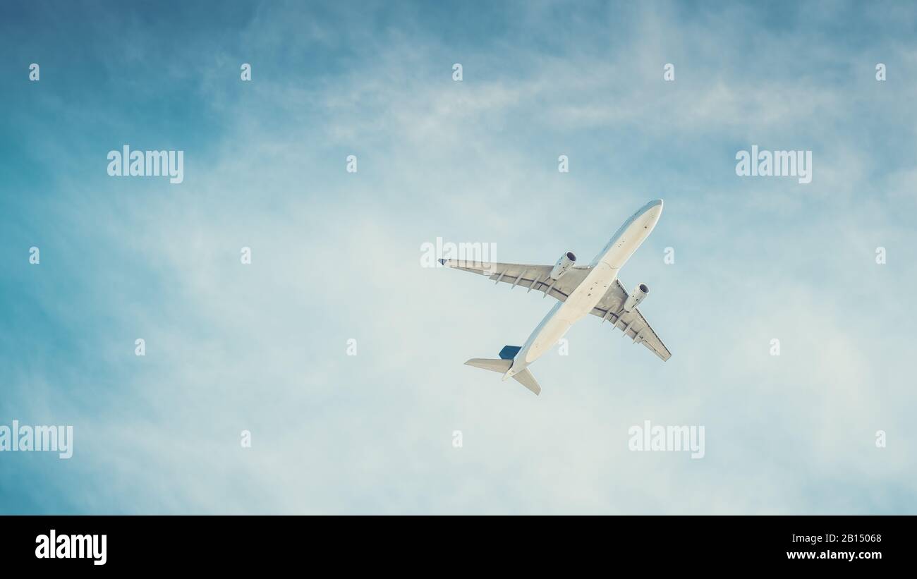 Big commercial passenger airplane taking off into blue sky viewed from ...