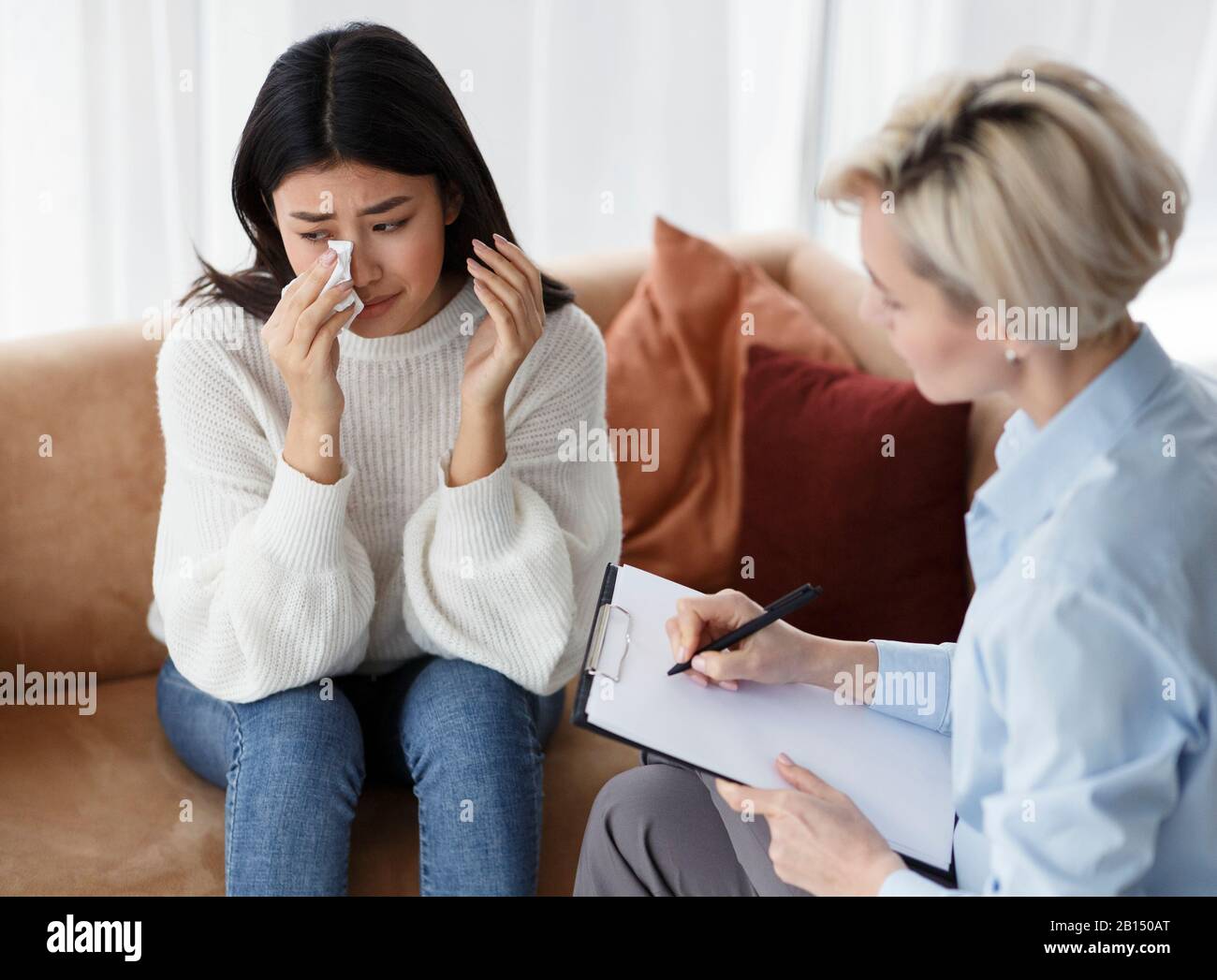 Asian Woman Crying Talking With Psychologist Sitting In Office Stock ...