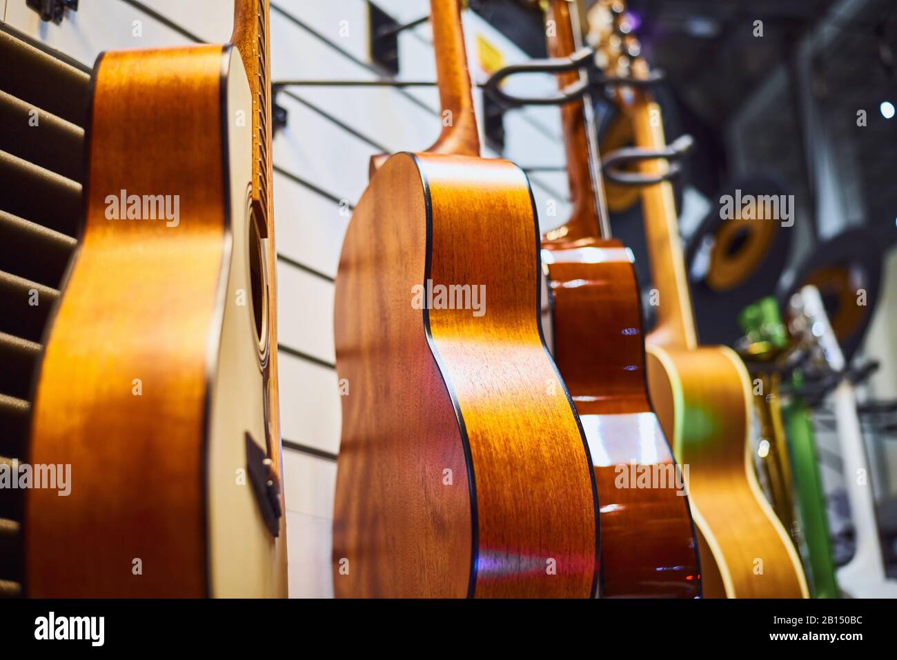 Row of classic acoustic guitars in the store Stock Photo - Alamy
