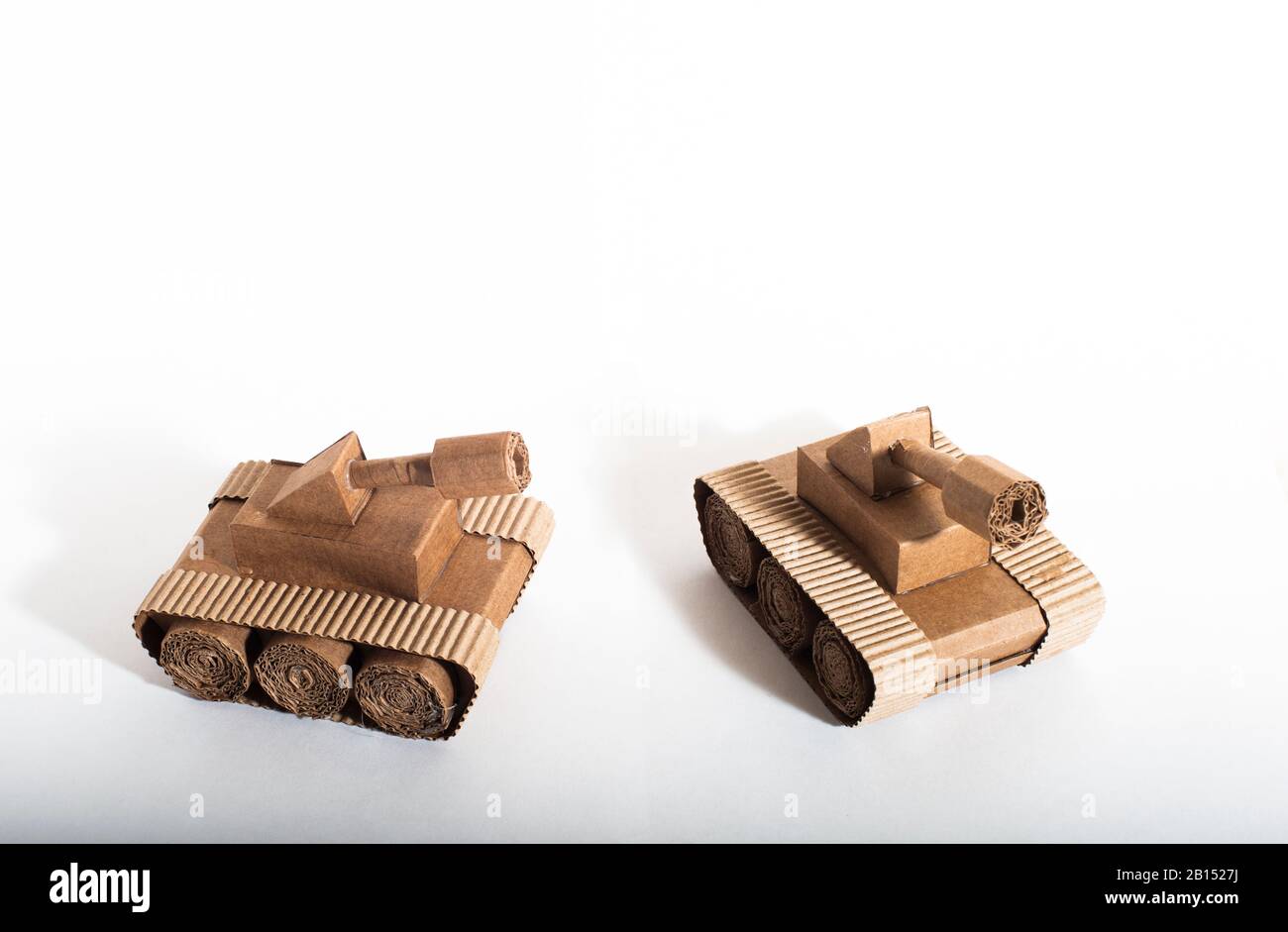 two toy tanks made by children from corrugated cardboard are fighting ...