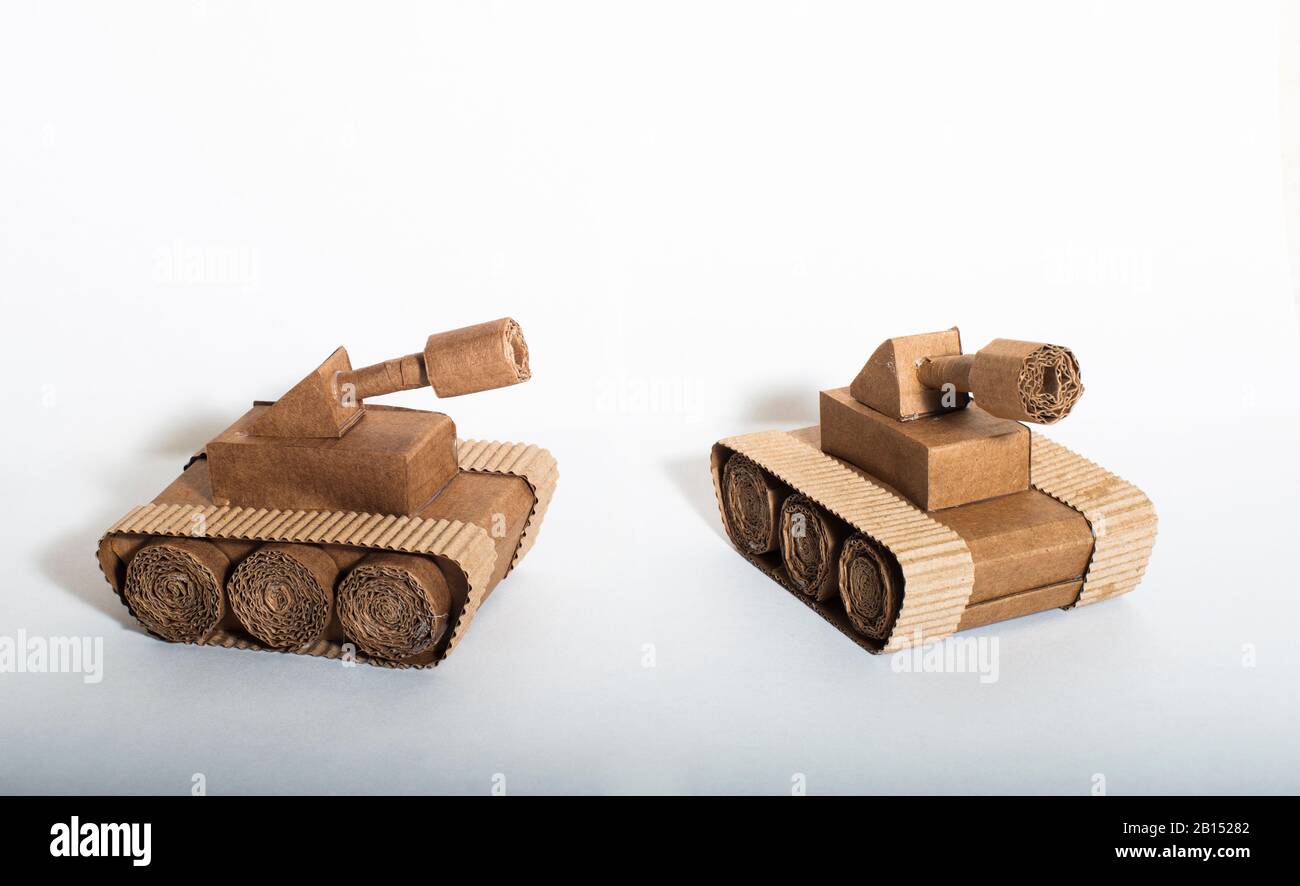 two toy tanks made by children from corrugated cardboard are fighting ...