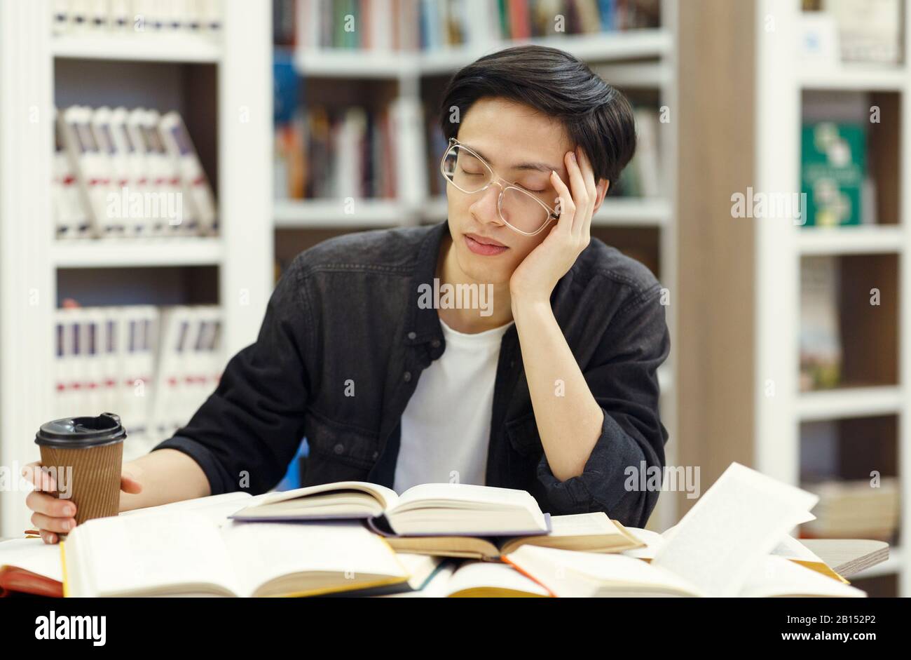 Stressed chinese guy sleeping in modern library Stock Photo - Alamy