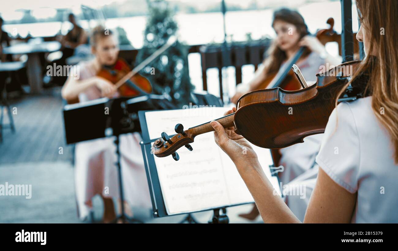 Group Of Two Violinists And One Cellist On The Terrace Stock Photo - Alamy