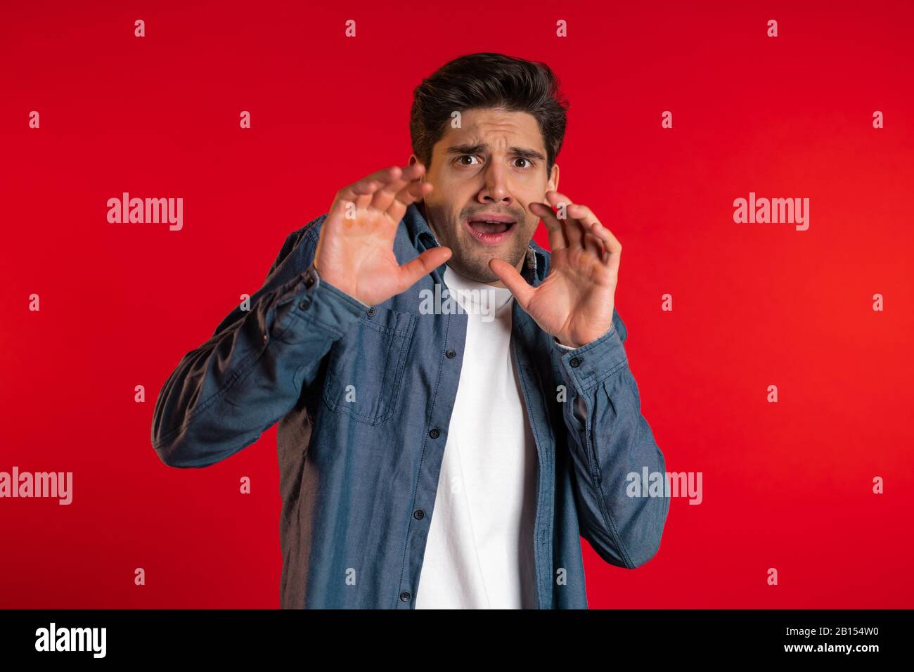 Frightened european man afraid of something and looks into camera with ...