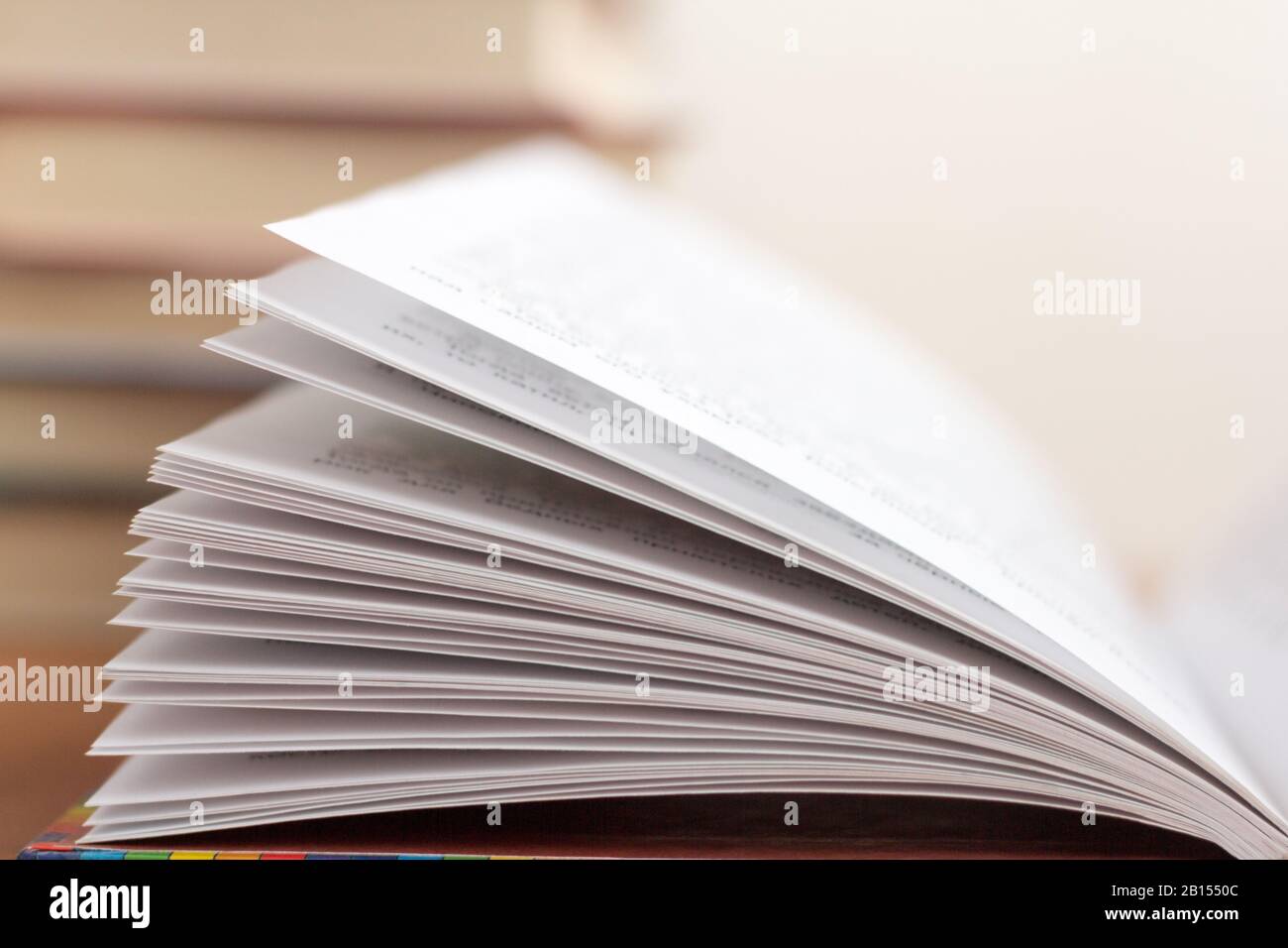 Open book, close-up, against the background of bookshelves Stock Photo ...