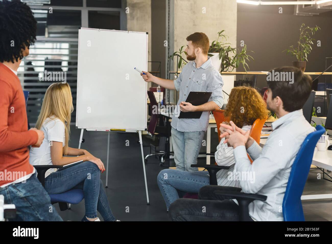 Young man presenting new marketing plan to creative team Stock Photo ...