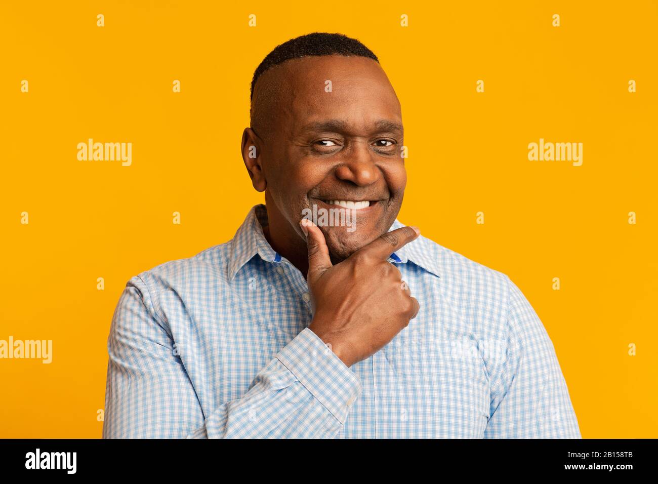 Flirty middle aged african man smiling at camera Stock Photo - Alamy