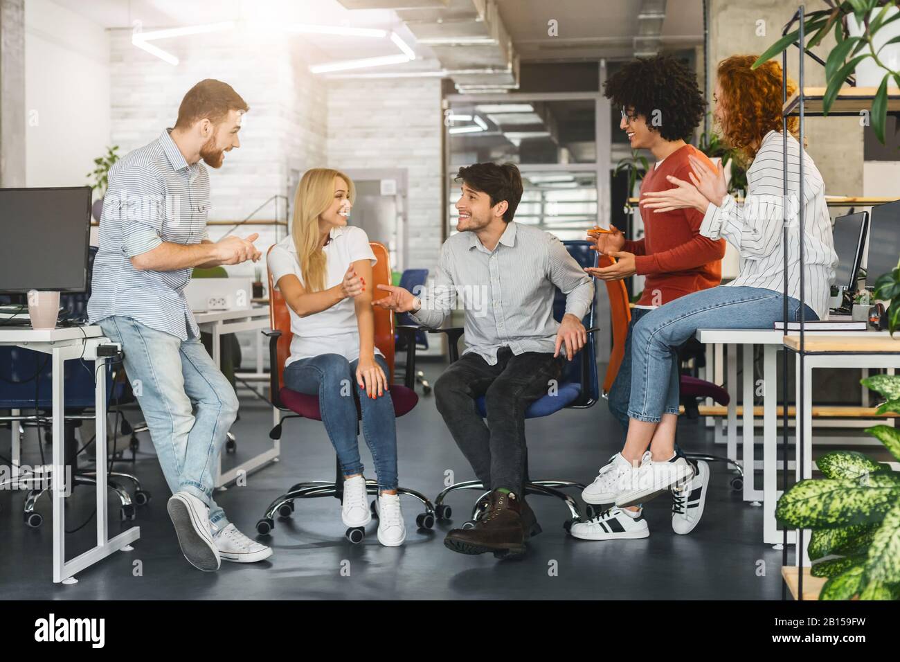 Happy young team enjoying time together, having break Stock Photo - Alamy