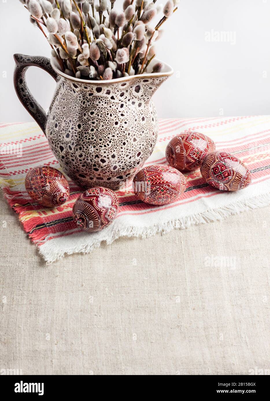 Easter still life with Pysanka and willow branches in ceramic jug on ...