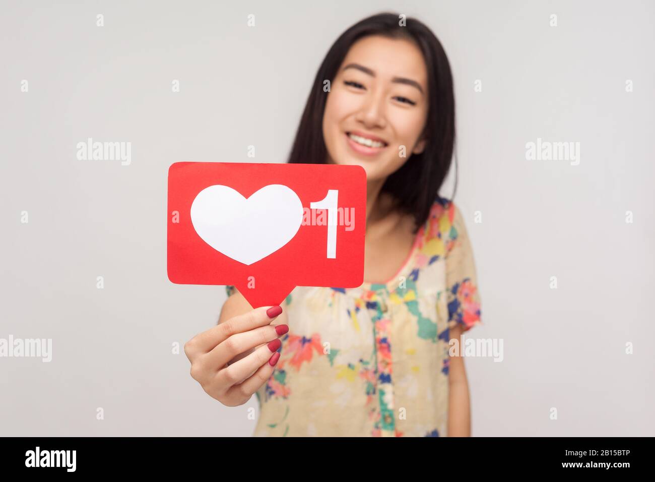 Push Like button! Glad cheerful asian girl with charming smile showing ...