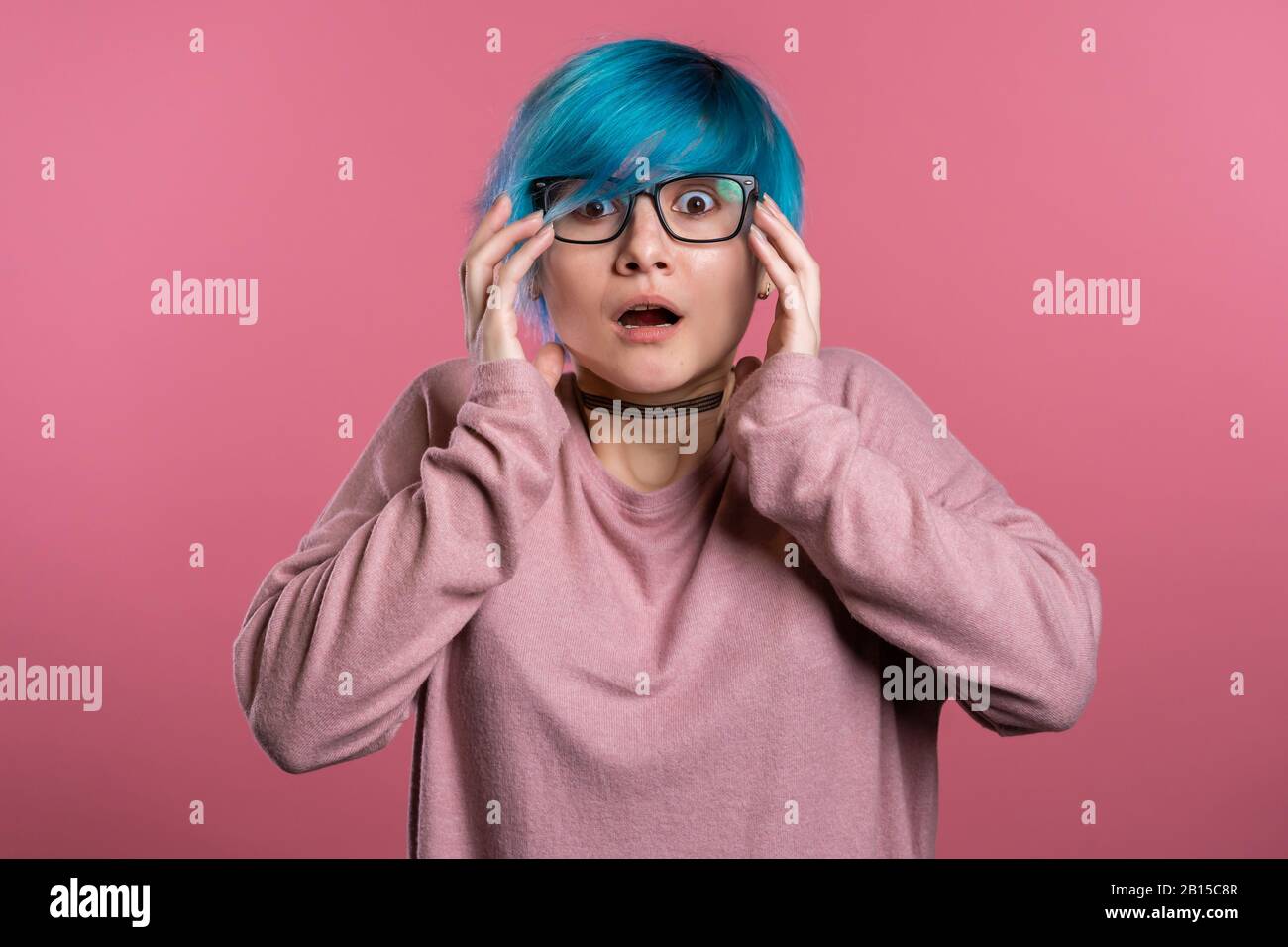 Close up of young scared girl with blue hairstyle shouting isolated ...