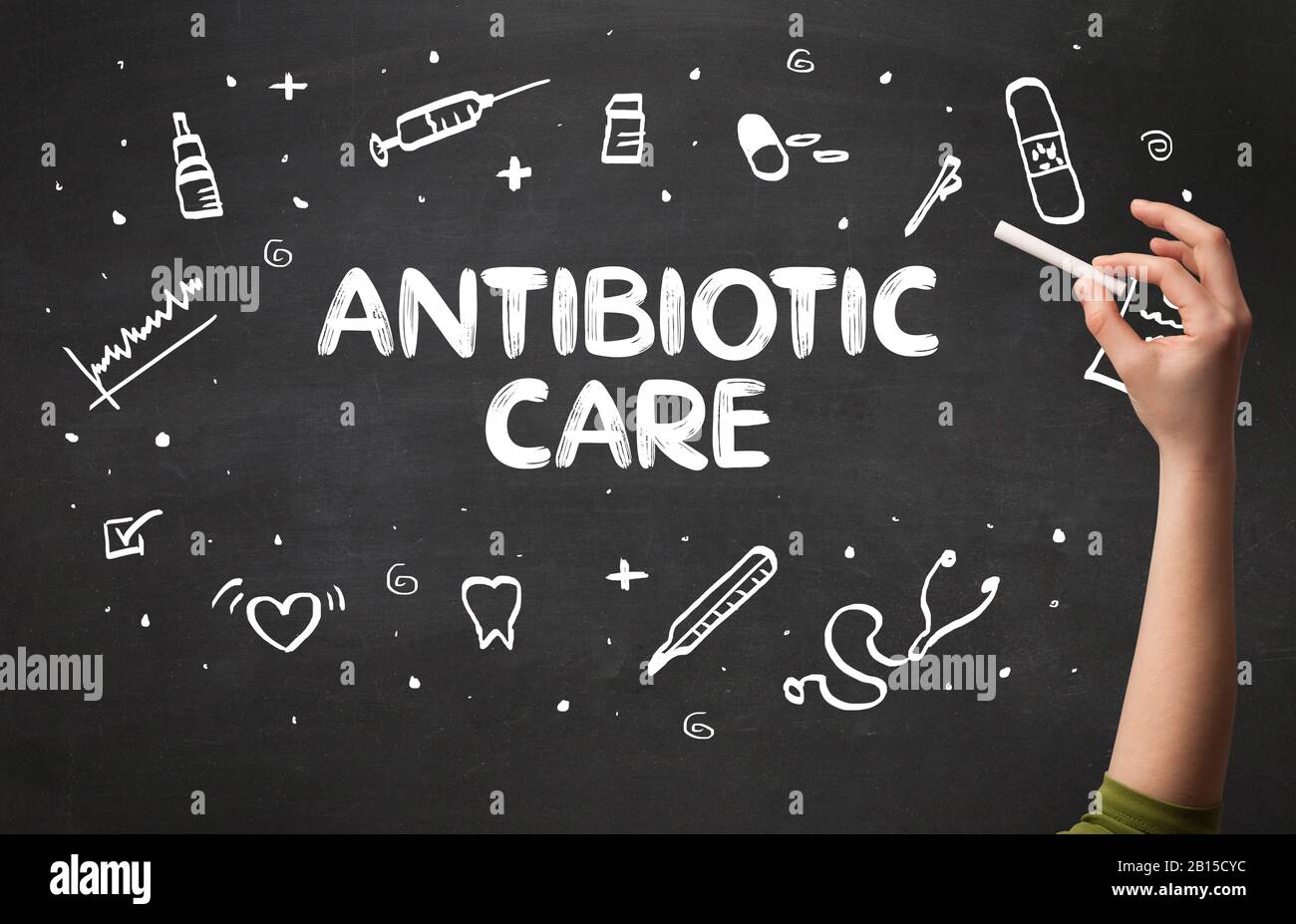 Hand drawing ANTIBIOTIC CARE inscription with white chalk on blackboard ...