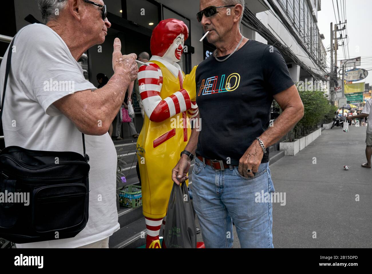 Smokers. Two men smoking cigarettes outside McDonlad's restaurant ...