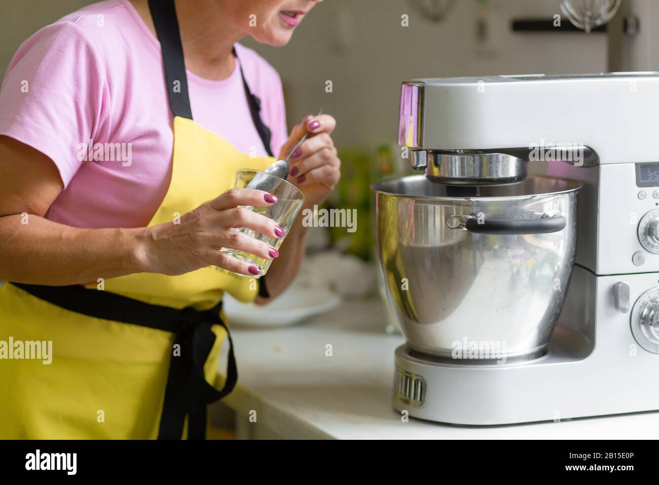 Woman professional pastry chef preparing a dessert. Adds ingredients ...