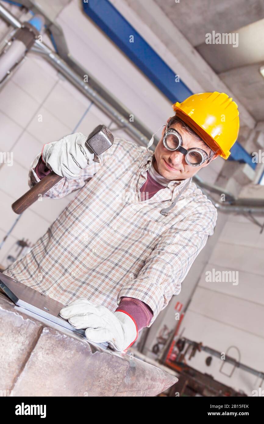 metalworker works metal with hammer on the anvil Stock Photo - Alamy