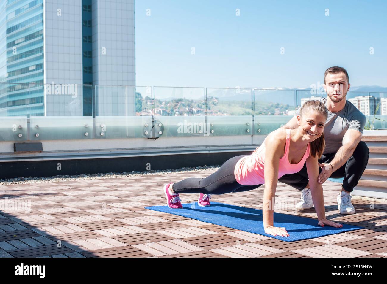 Personal trainer support and motivate his client while doing push ups ...