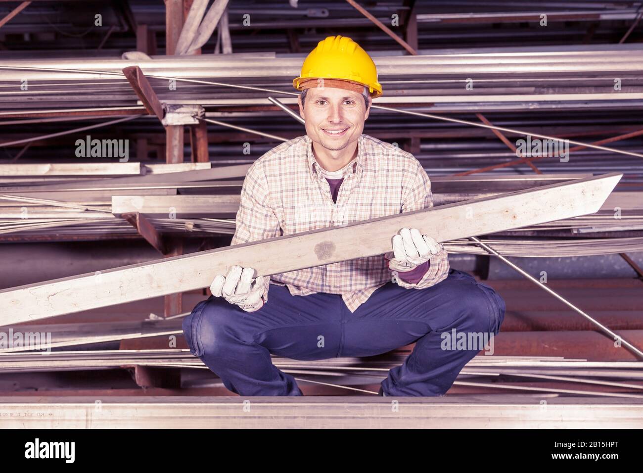 young metalworker controls some metal bars in steel mill Stock Photo ...
