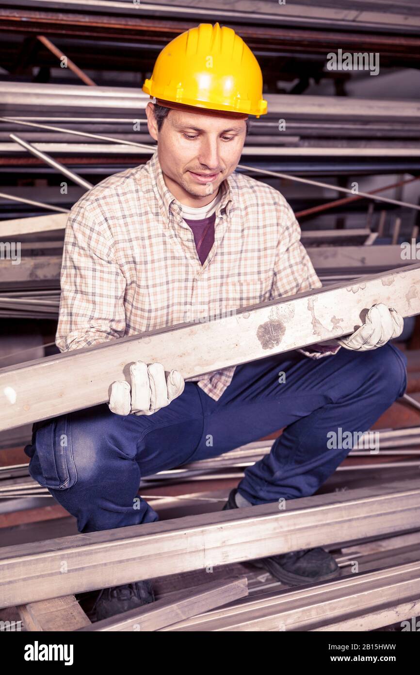 young metalworker controls some metal bars in steel mill Stock Photo ...