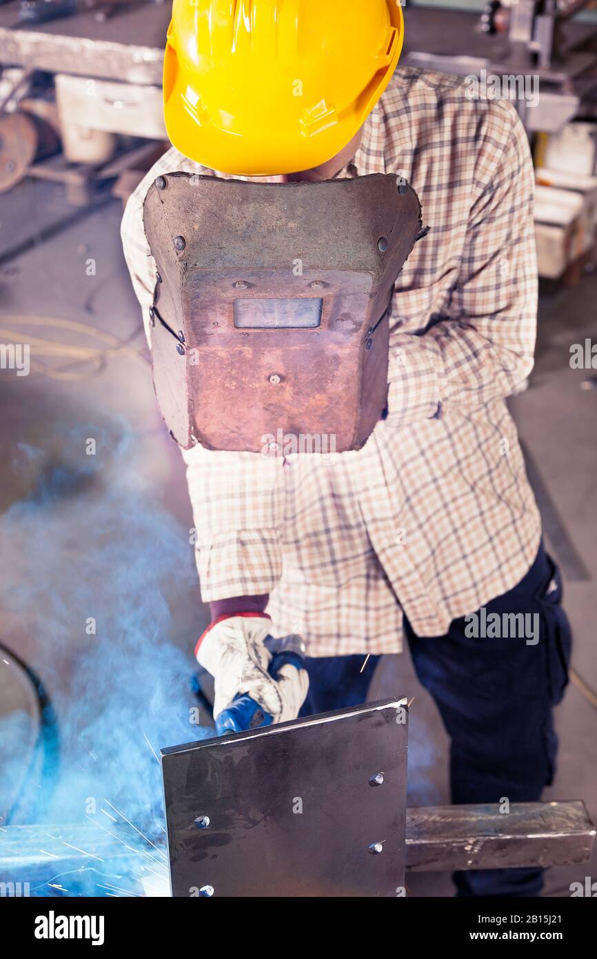 young worker while welding in a steel mill Stock Photo - Alamy