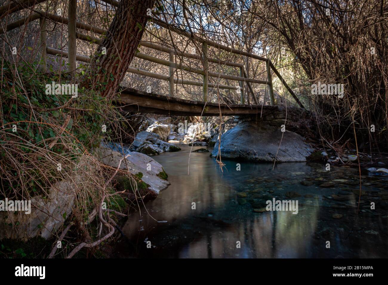 Wooden bridge between trees on the Dilar river Stock Photo - Alamy