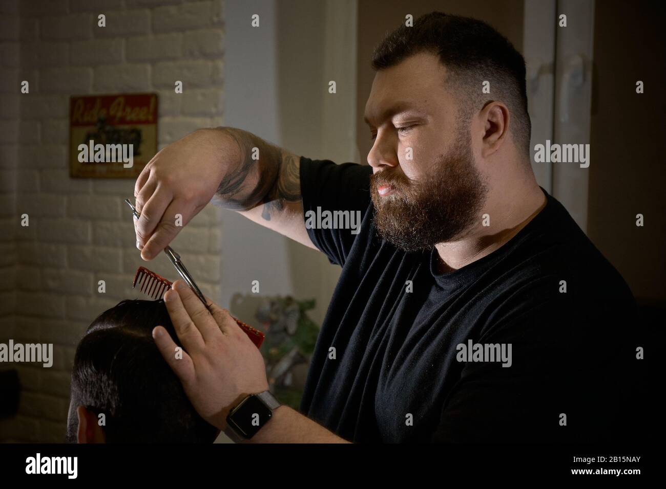 Brutal professional Barber doing hairstyle to his client. Hairdresser ...