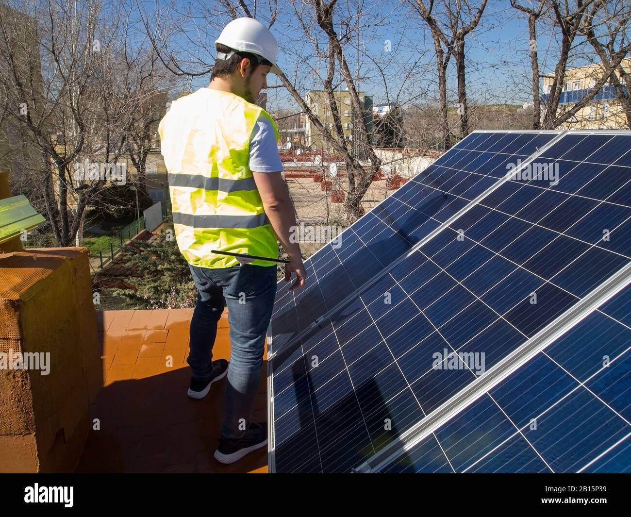 Caucasian attractive young technician looking at the solar panels with ...