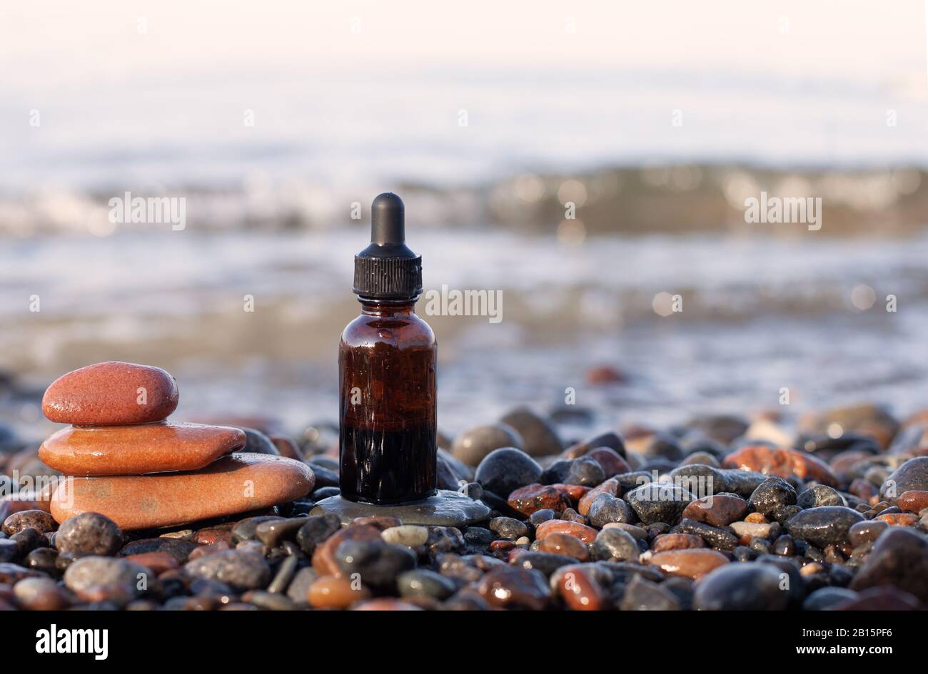 Bottle with herb extract, pebbles on the beach - Homeopathy. Natural ...