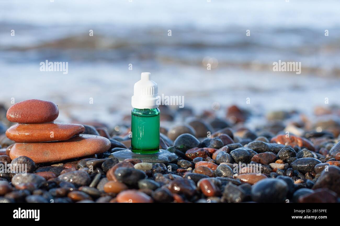 Homeopathy - a medicine green bottle on the beach. Naturotherapy ...