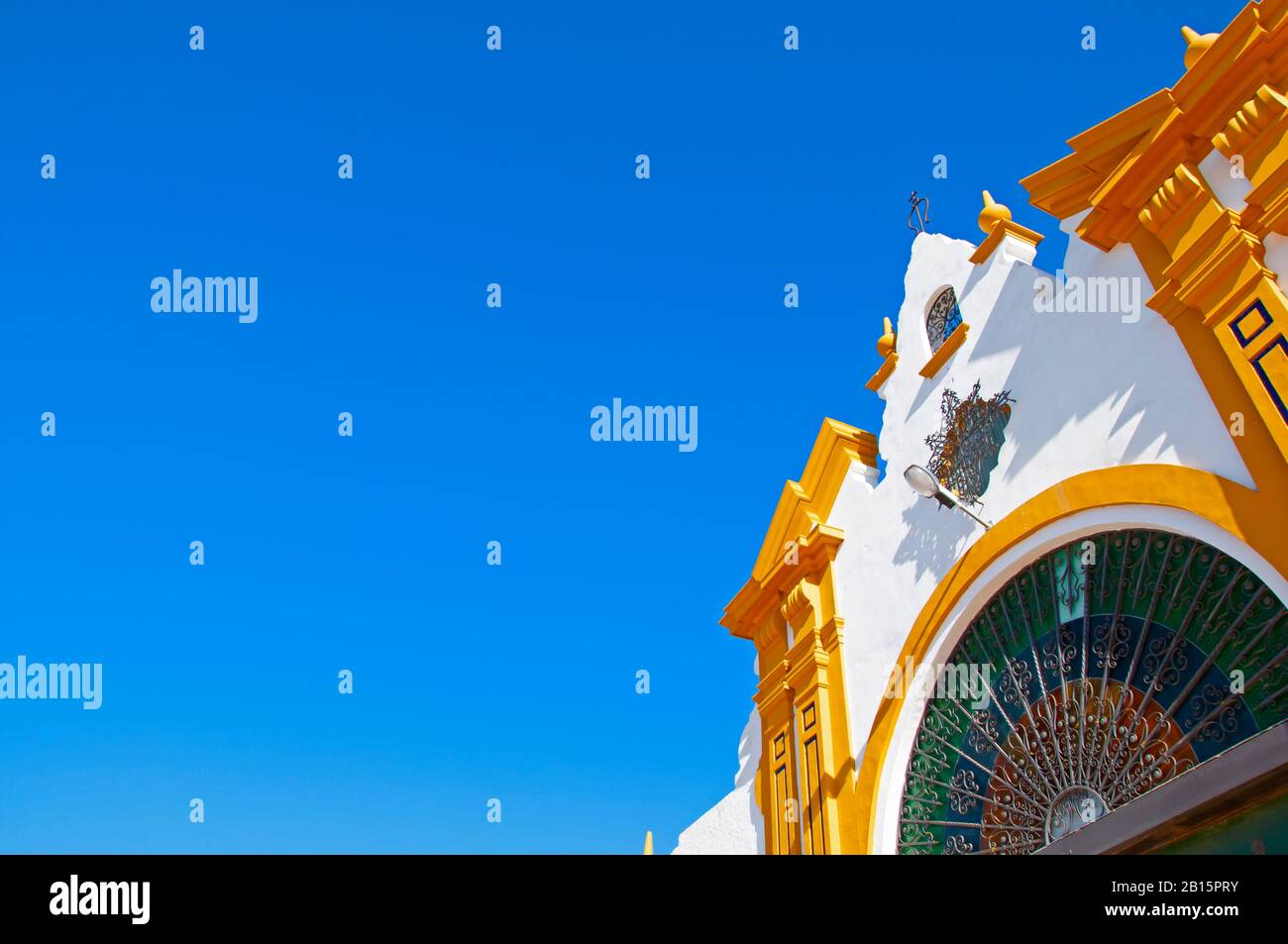 Upper decorative part of architectural building in white and yellow ...
