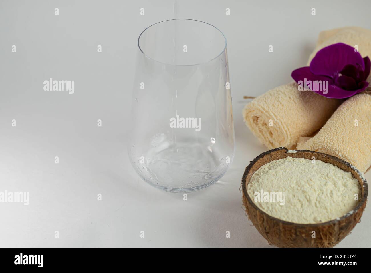 Collagen powder in half coconut with a spoon for measuring quantity ...