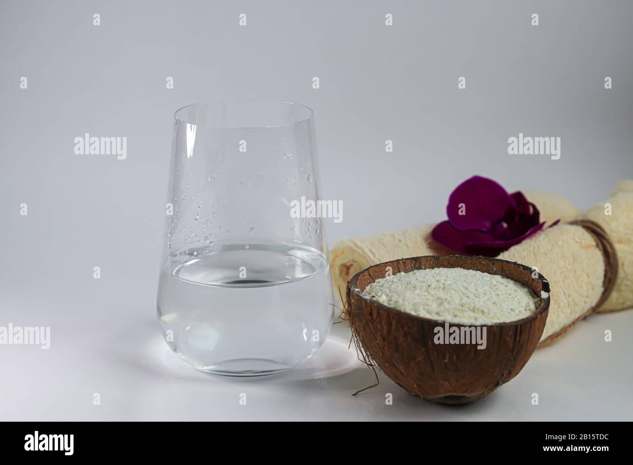 Collagen powder in half coconut with a spoon for measuring quantity ...