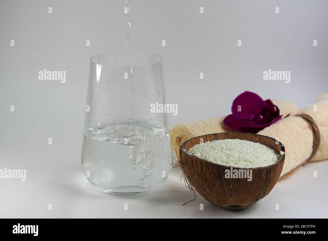 Collagen powder in half coconut with a spoon for measuring quantity ...