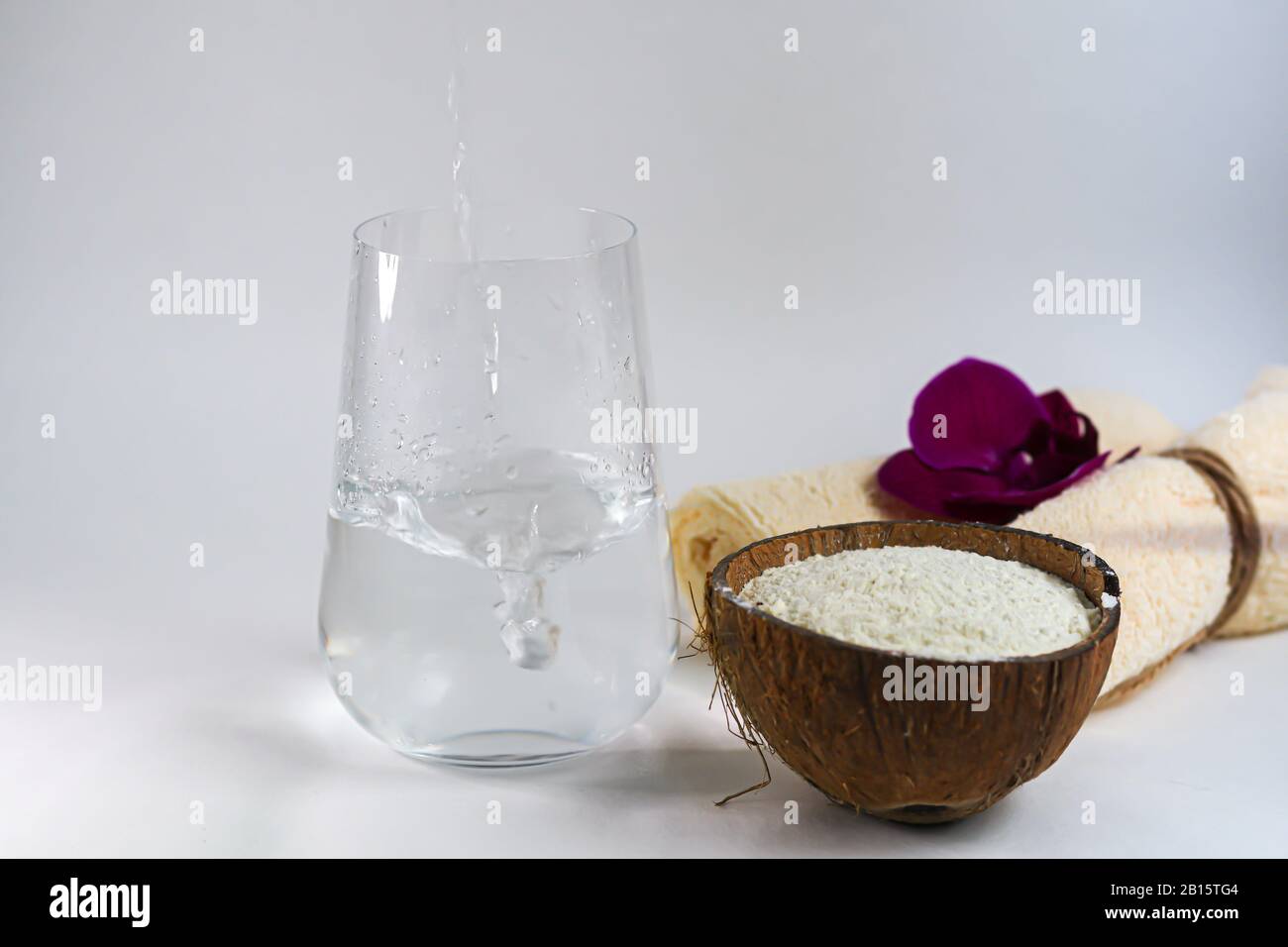 Collagen powder in half coconut with a spoon for measuring quantity ...